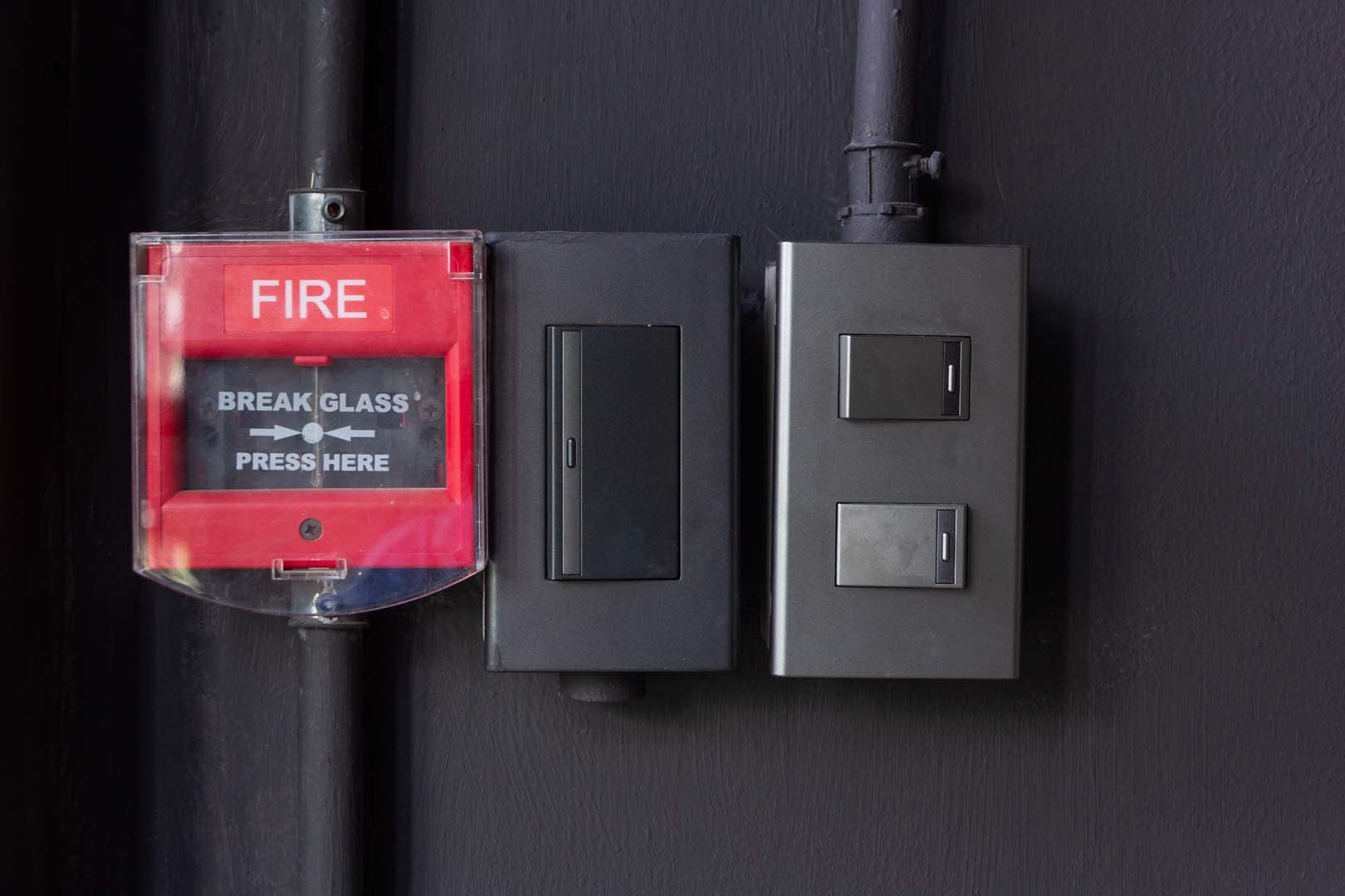 Red fire alarm box and on black background in factory | Triple A Fire ...